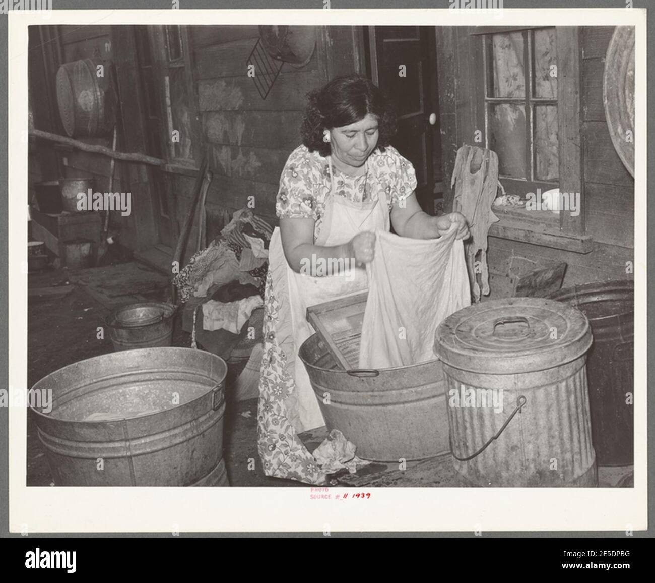 Mexican woman washing in front of house in corral. Mexican section, San ...