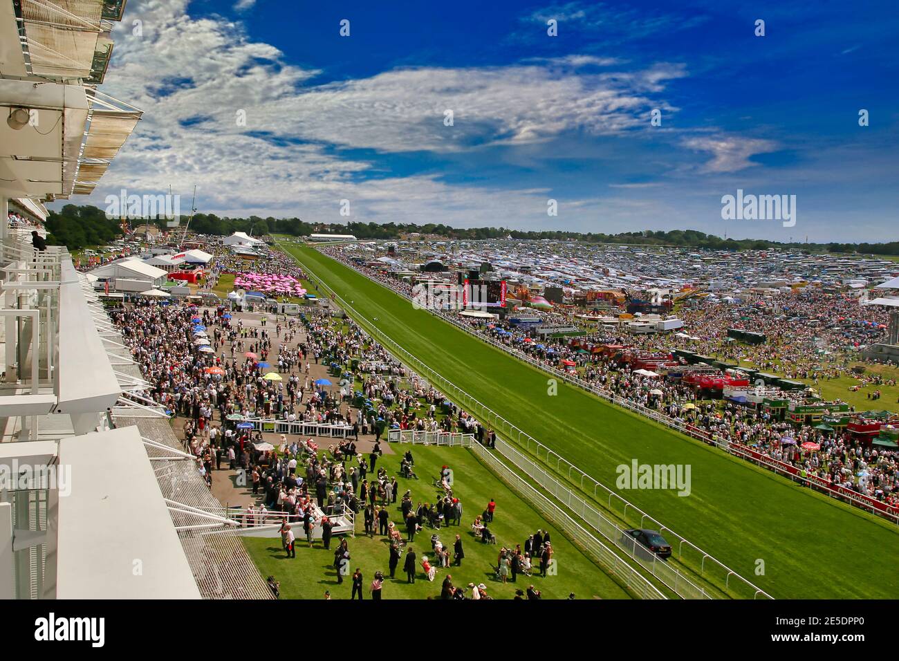 Huge crowd lines the finish straight during horse racing at Epsom Downs ...