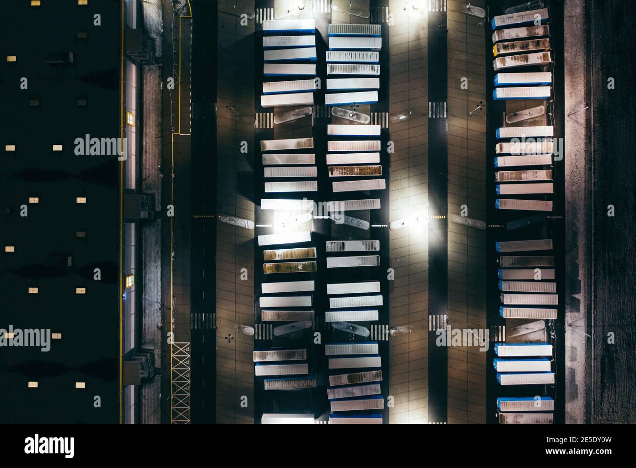 Aerial view of the trucks unloading at the logistic center. Night view ...
