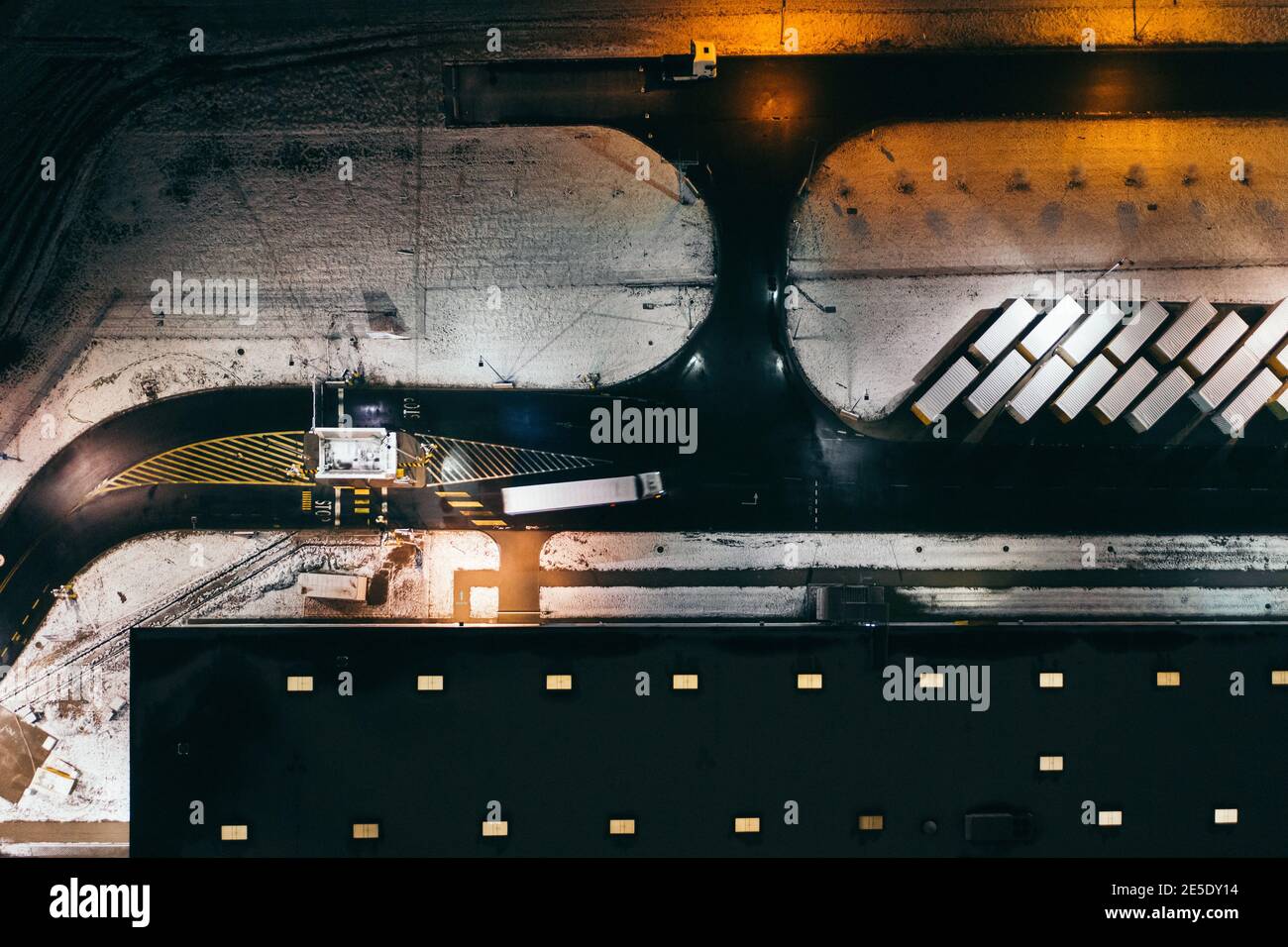 Aerial view of the trucks unloading at the logistic center. Night view ...