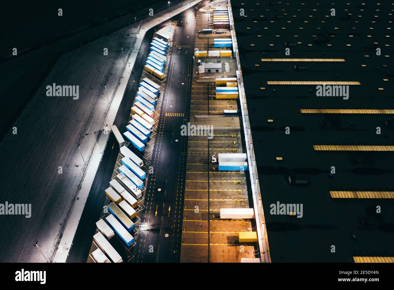 Aerial view of the trucks unloading at the logistic center. Night view ...