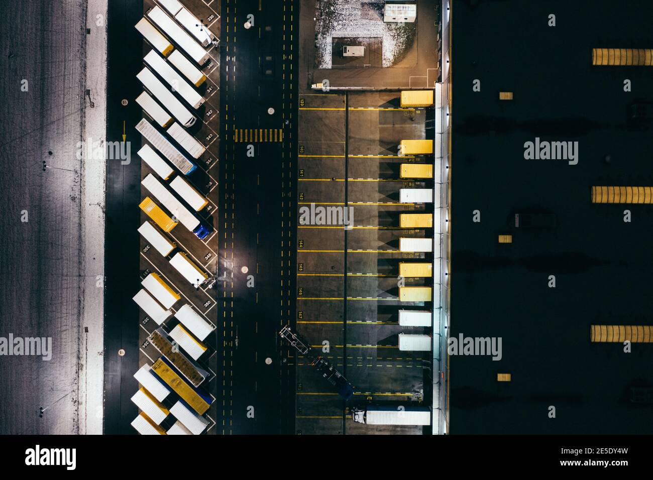 Aerial view of the trucks unloading at the logistic center. Night view ...