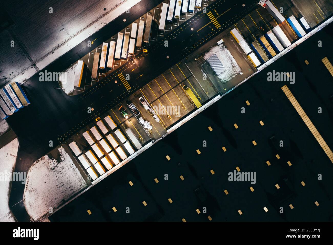 Aerial view of the trucks unloading at the logistic center. Night view ...