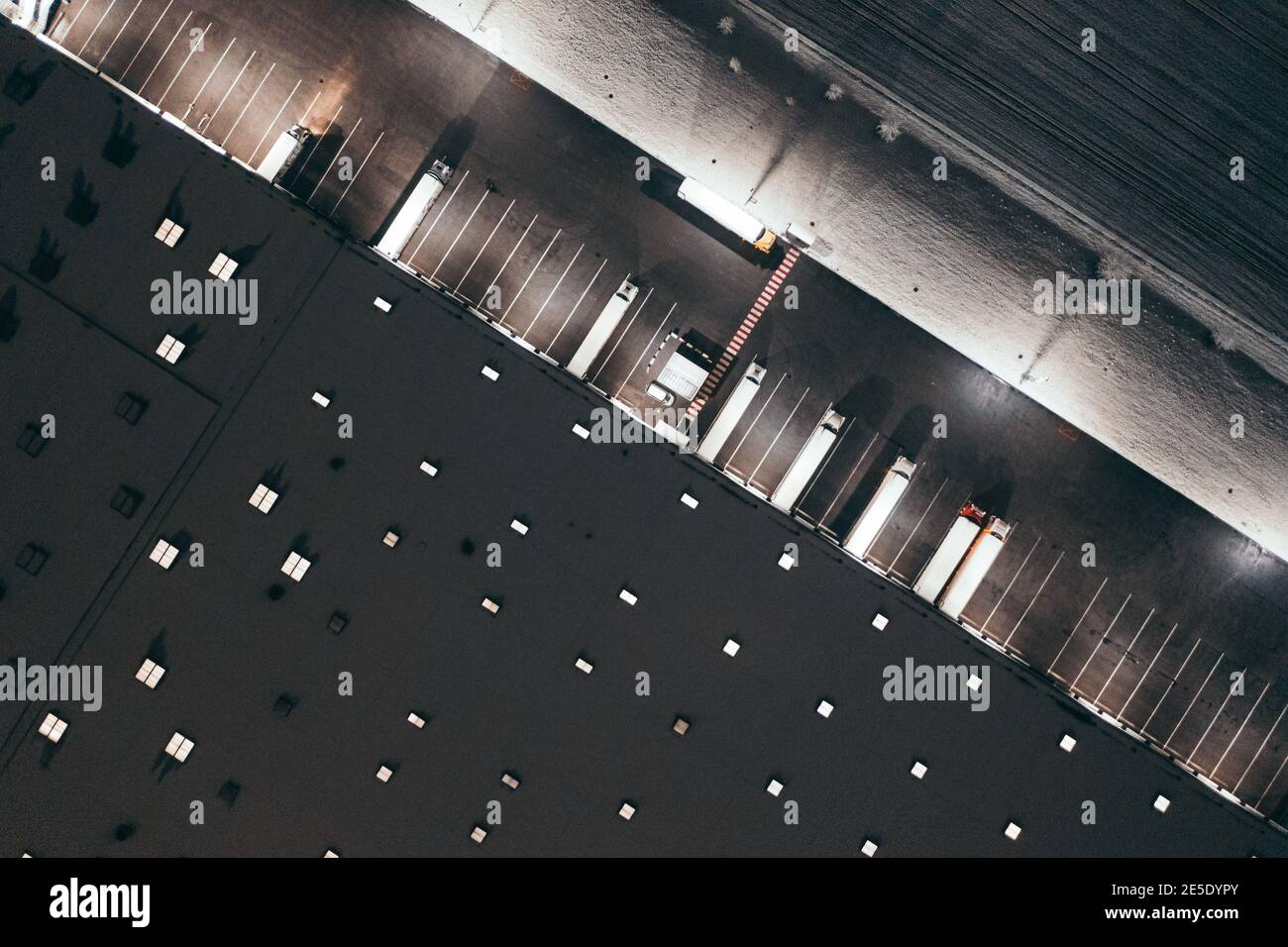 Aerial view of the trucks unloading at the logistic center. Night view ...