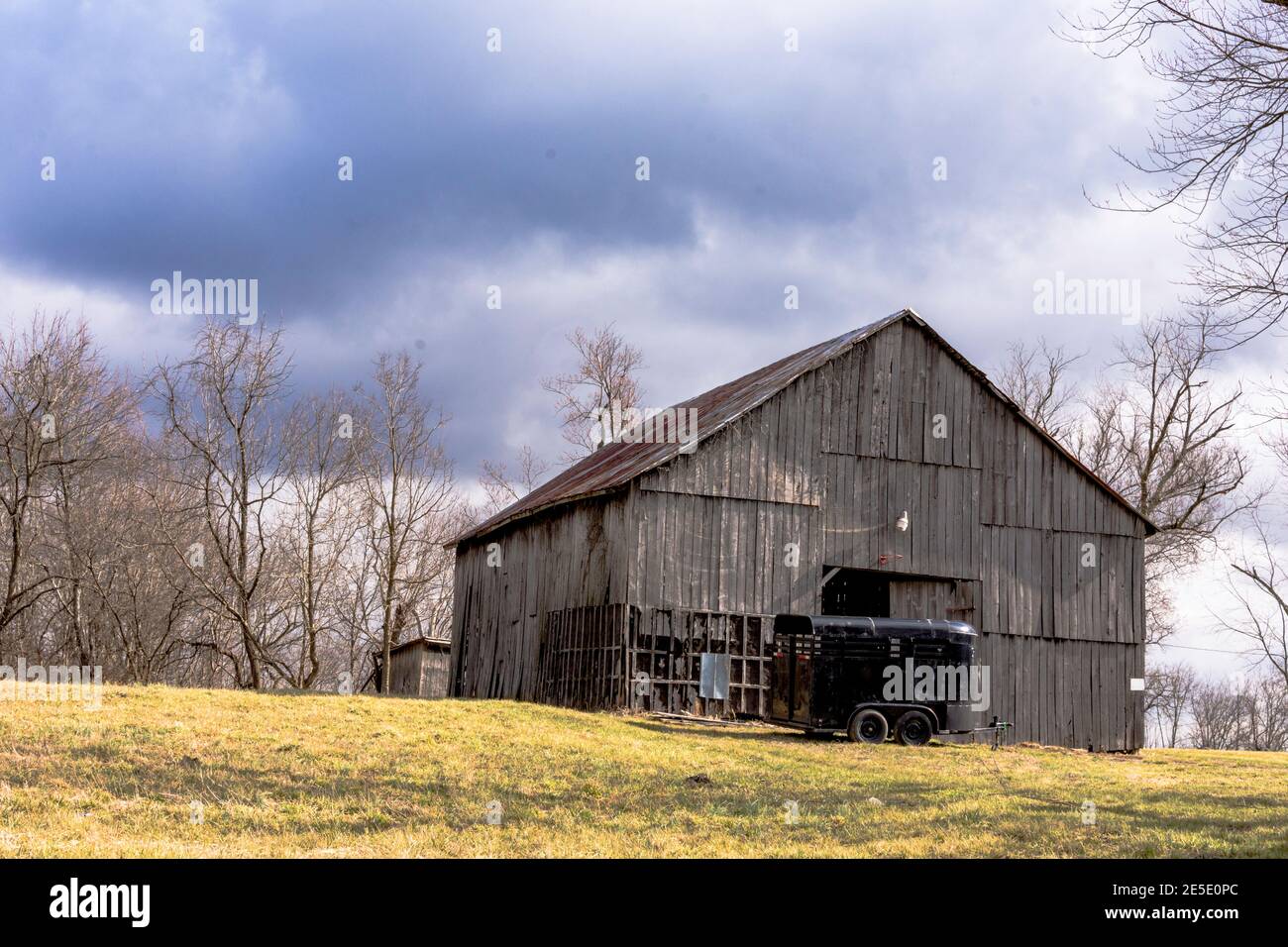 Old barn with a horse trailer parked in front Stock Photo - Alamy