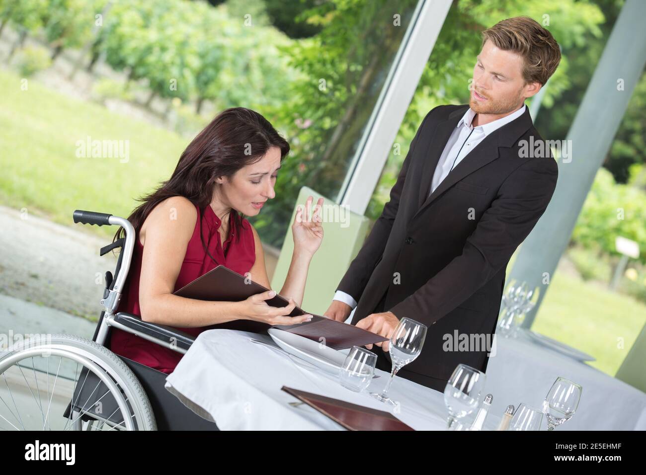 woman in a wheelchair eating at a restaurant Stock Photo - Alamy