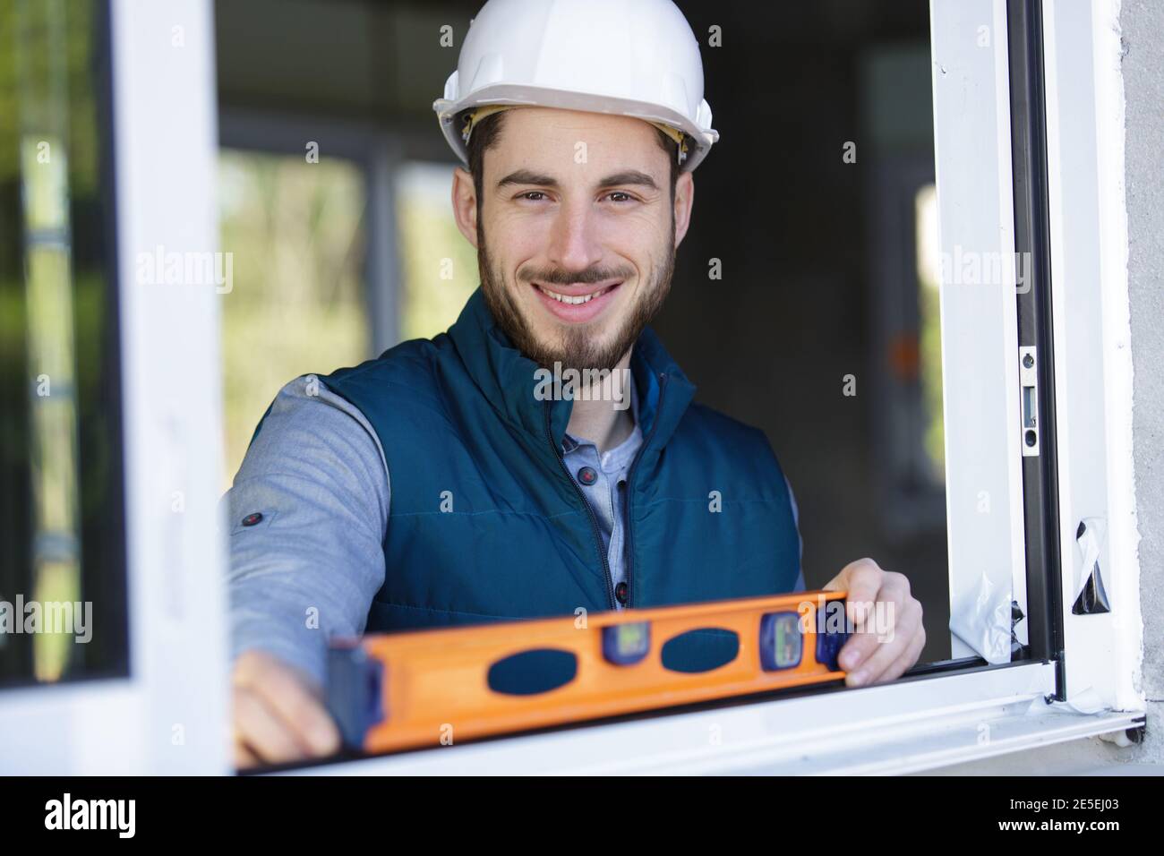 workman using spirit level to check window installation Stock Photo - Alamy