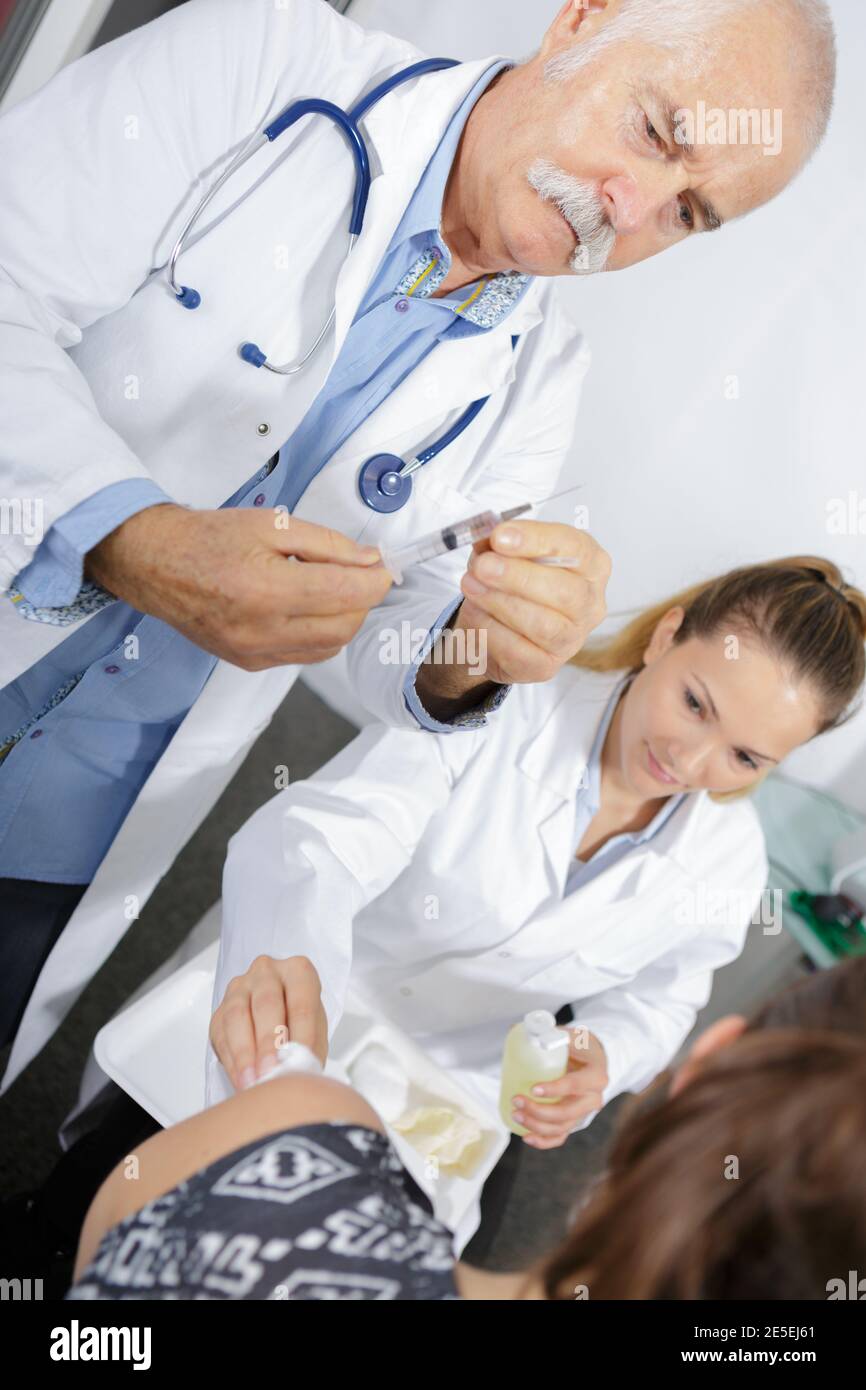 senior doctor injecting patient with syringe to collect blood Stock ...