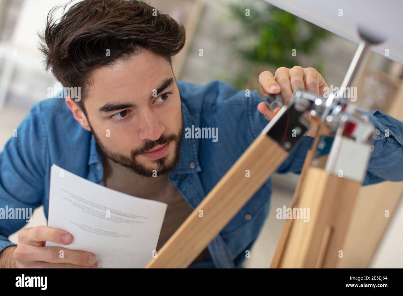 man putting together self assembly furniture in new home Stock Photo ...