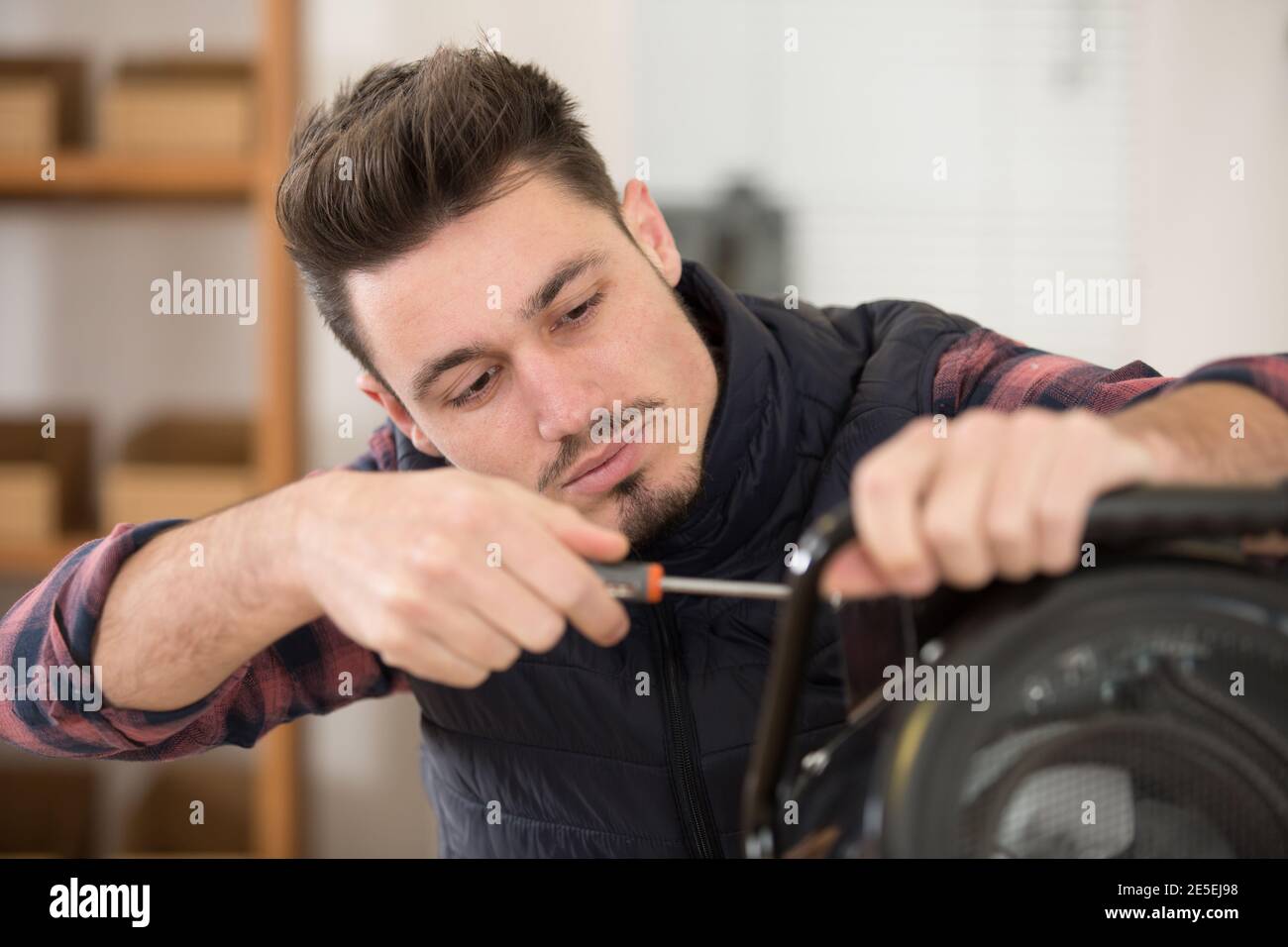 man unscrewing a screw-nut on a heater Stock Photo - Alamy