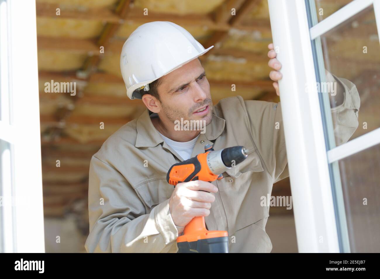 construction worker using drill to install replacement window Stock ...