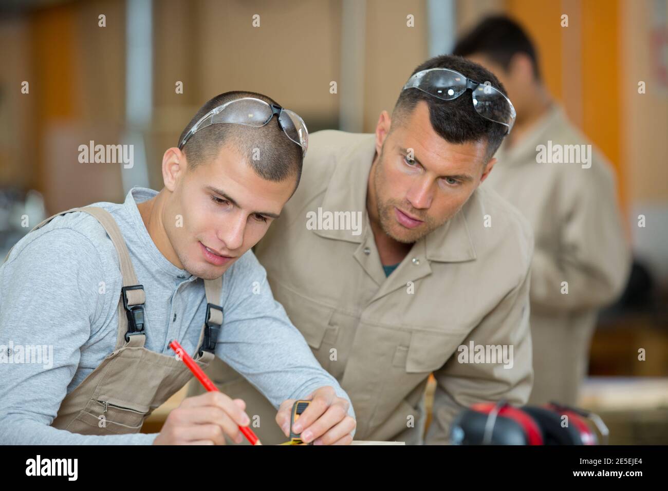 young apprentice with teacher working with wood Stock Photo - Alamy