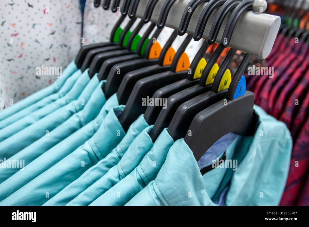 Fashion clothes on clothing rack - bright colorful closet. Close-up of ...