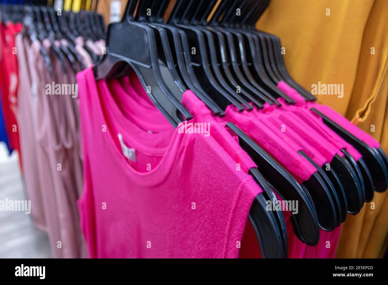 Fashion clothes on clothing rack - bright colorful closet. Close-up of ...