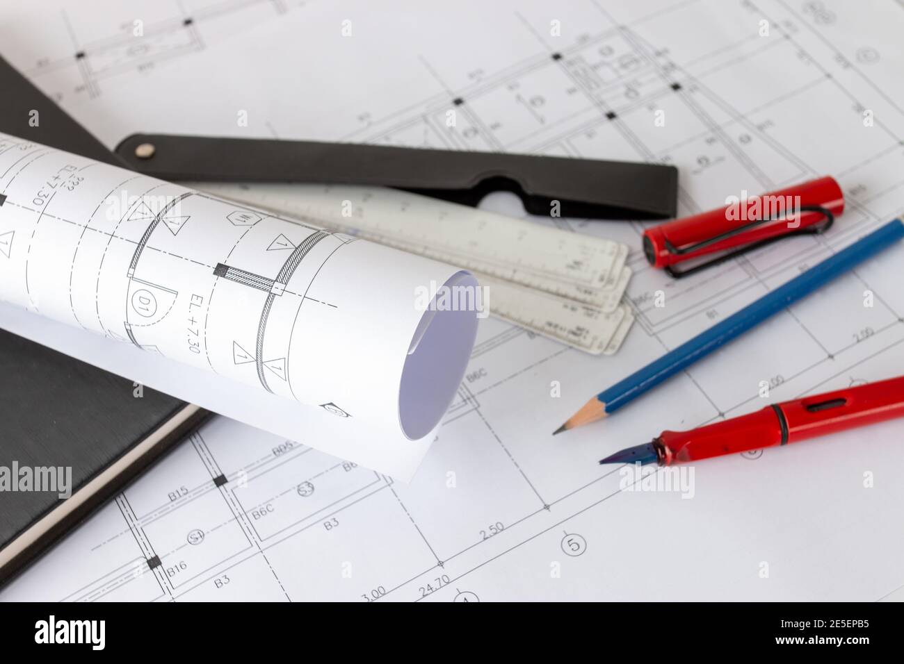 Rolls of architecture blueprints and house plans on the table and ...