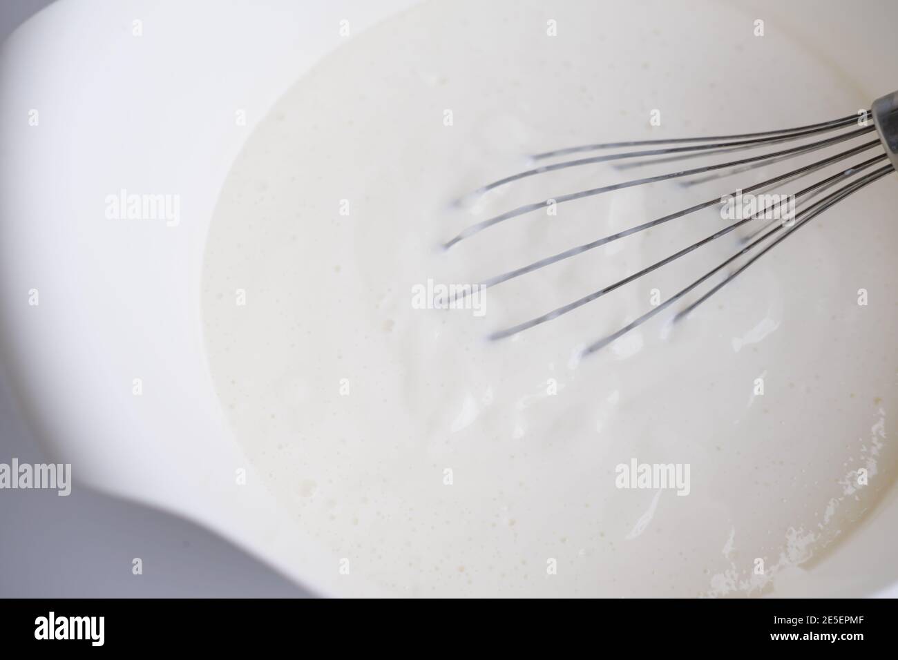 a bowl with whipped cream and a whisk. making frosting for a cake ...