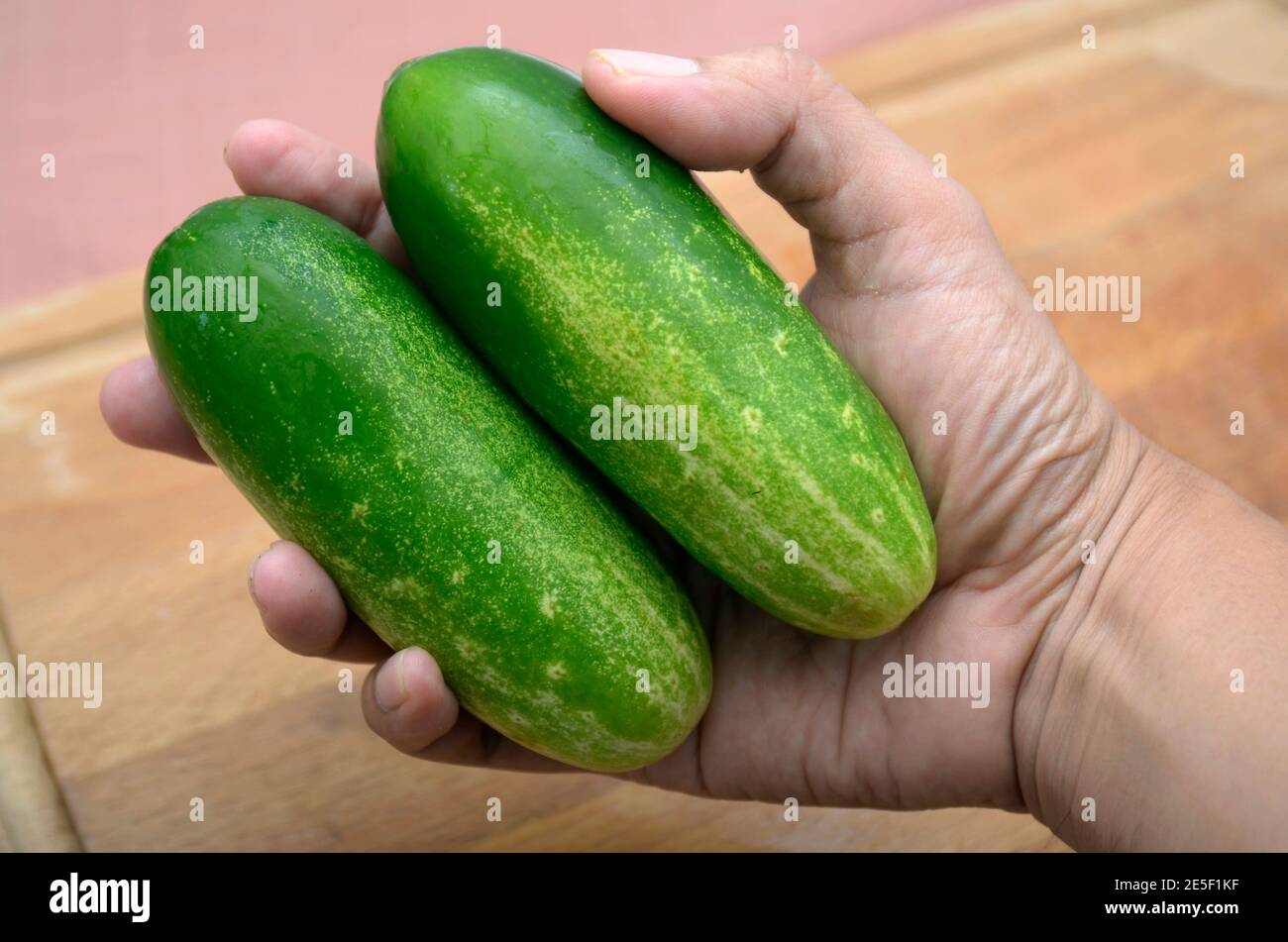 two cucumbers in a hand Stock Photo - Alamy