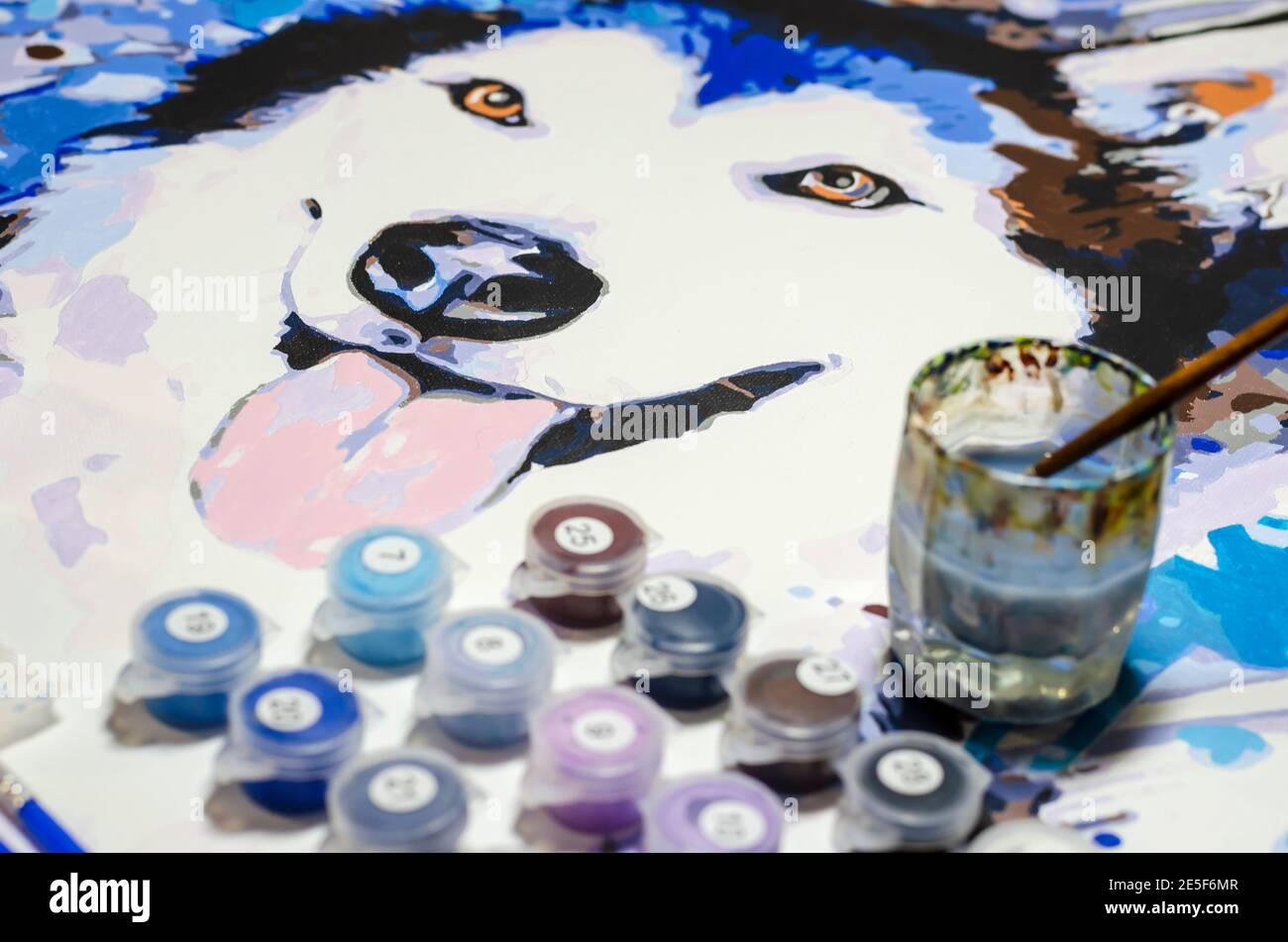 Colorful picture of husky dog on canvas, paint cans and brushes ...