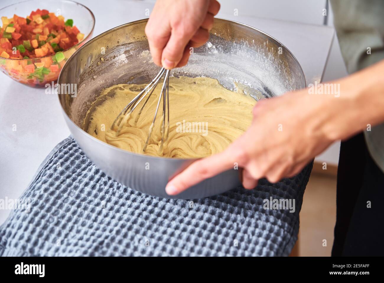 Woman in the kitchen cooking a cake. Hands beat the dough with mixer ...