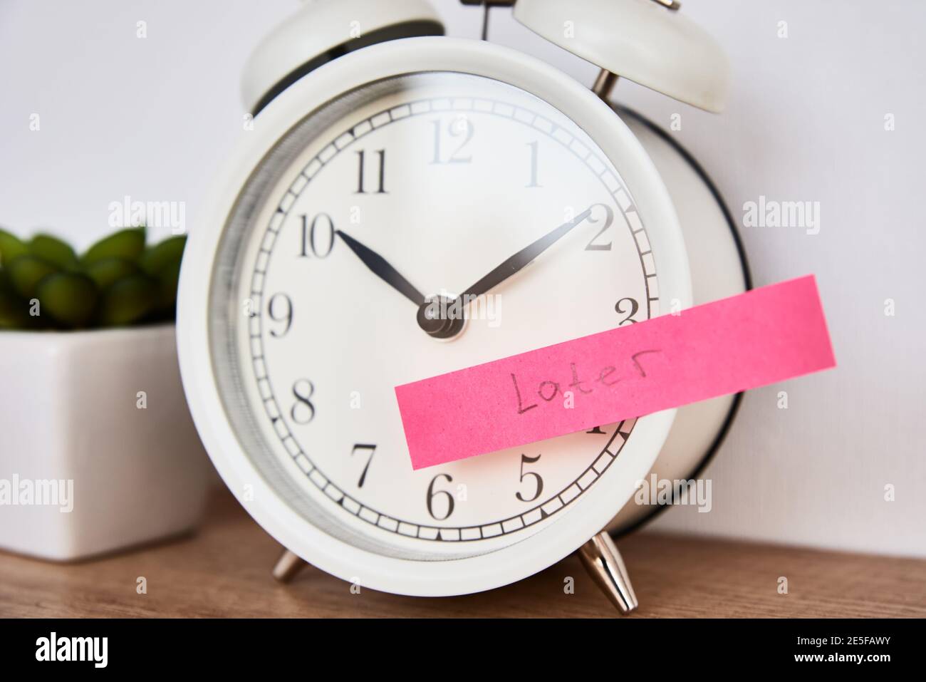 Procrastination and delay concept. Sticky note with word later on the ...