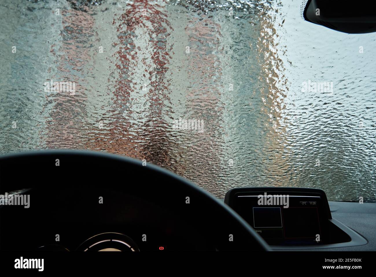 Inside view from car covered in freezing rain. Ice on a car windshield ...