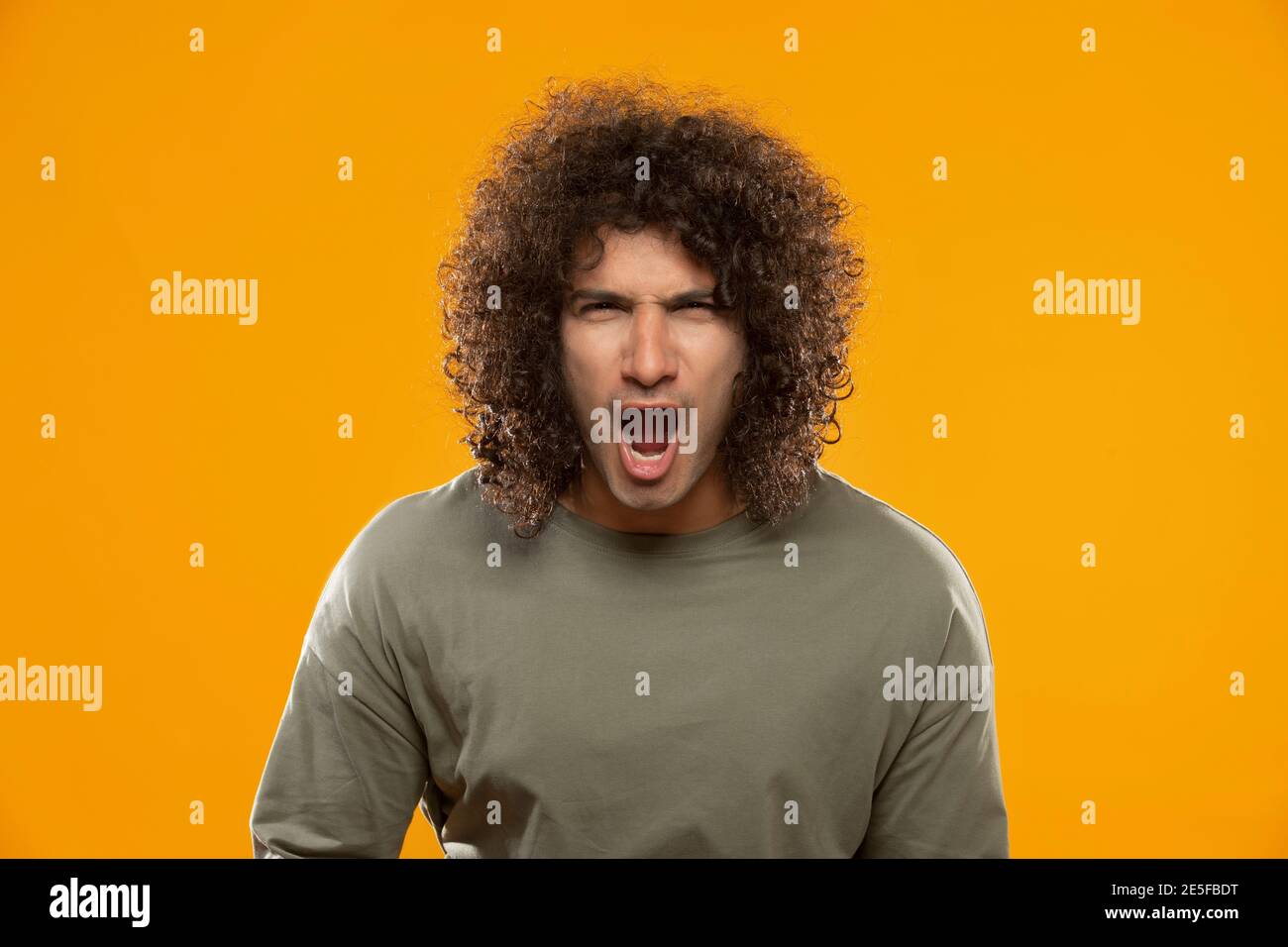 A CURLY HAIRED MAN SCREAMING IN ANGER Stock Photo - Alamy