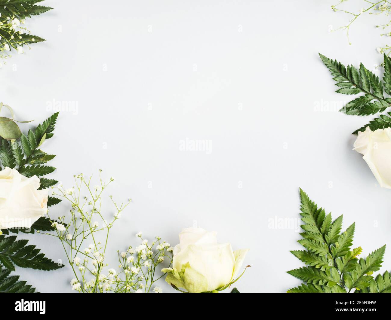 Floral arrangement frame with white roses and fern Stock Photo - Alamy