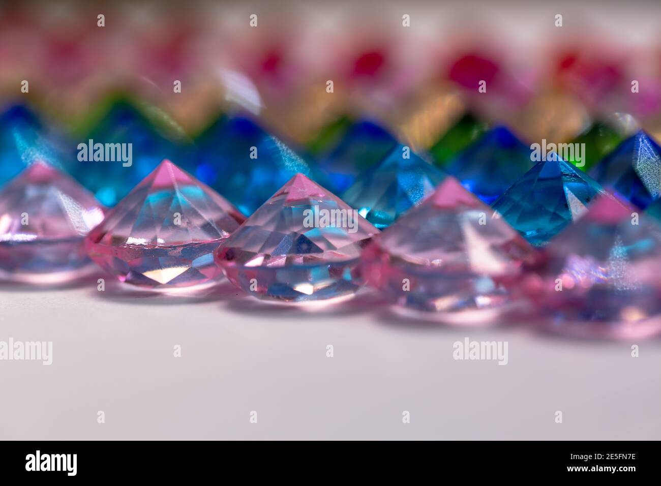 Colorful diamonds are arranged neatly in a row on a white floor Stock ...