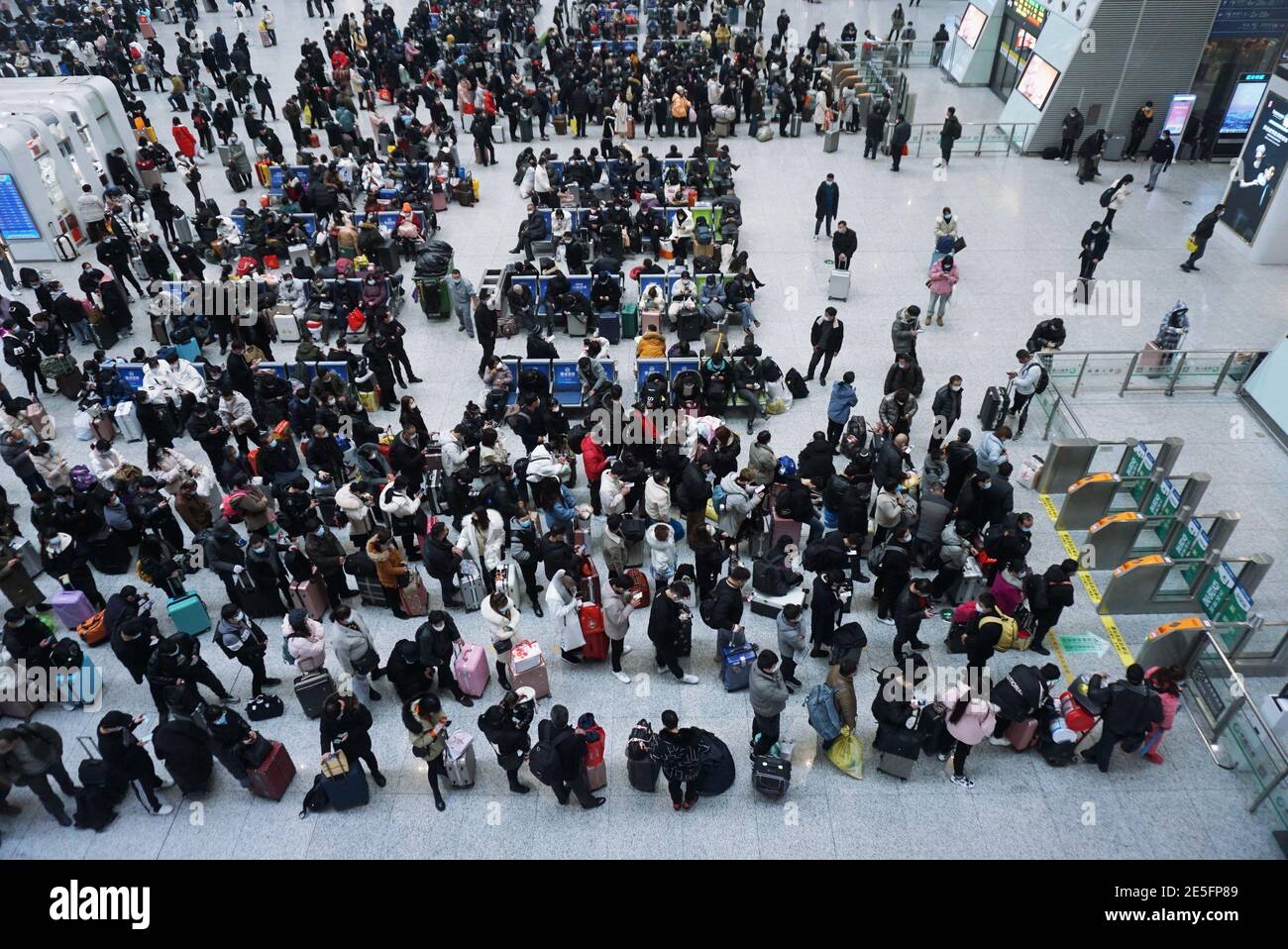 Passengers queue up to get onboard trains on the first day of 2021 ...