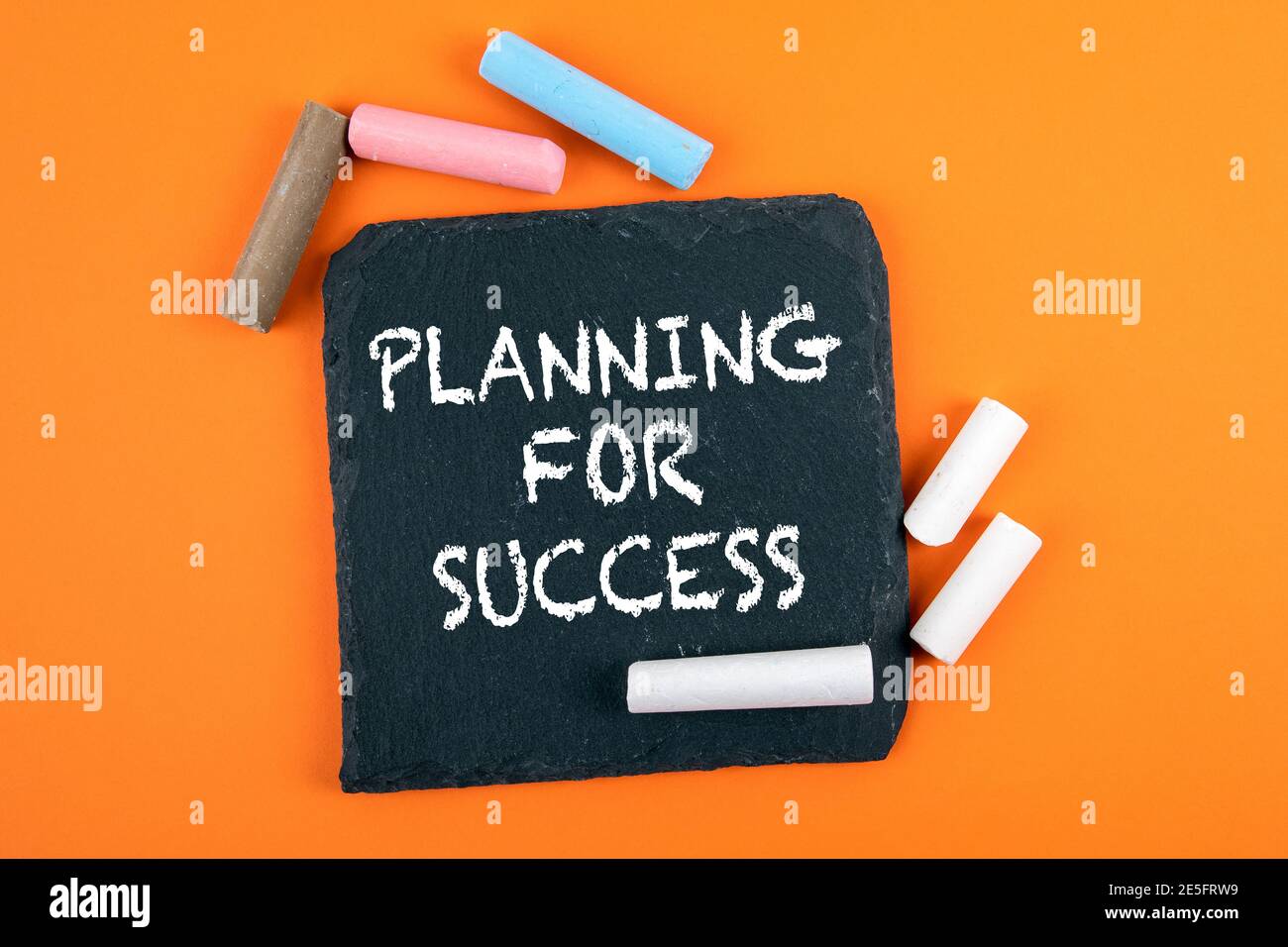 PLANNING FOR SUCCESS. Text on a stone surface. Chalk on an orange ...