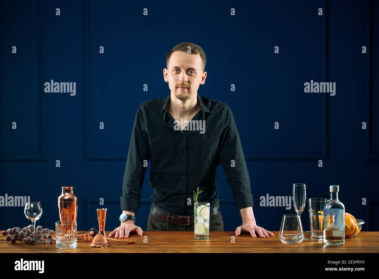 Man bartender standing behind desk with gin tonic Stock Photo - Alamy