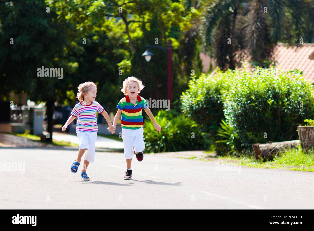 Kids running. Children run on city suburbs street on sunny summer day ...