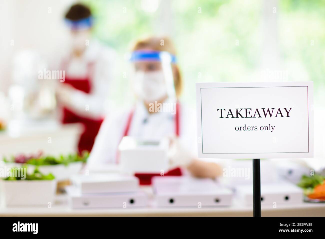 Food takeaway in restaurant in coronavirus outbreak. Cafe staff in face ...