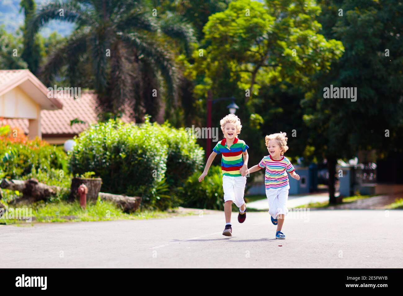 Kids running. Children run on city suburbs street on sunny summer day ...
