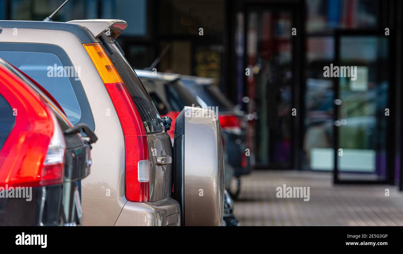 a row of cars in the parking lot outside the office building, close-up ...
