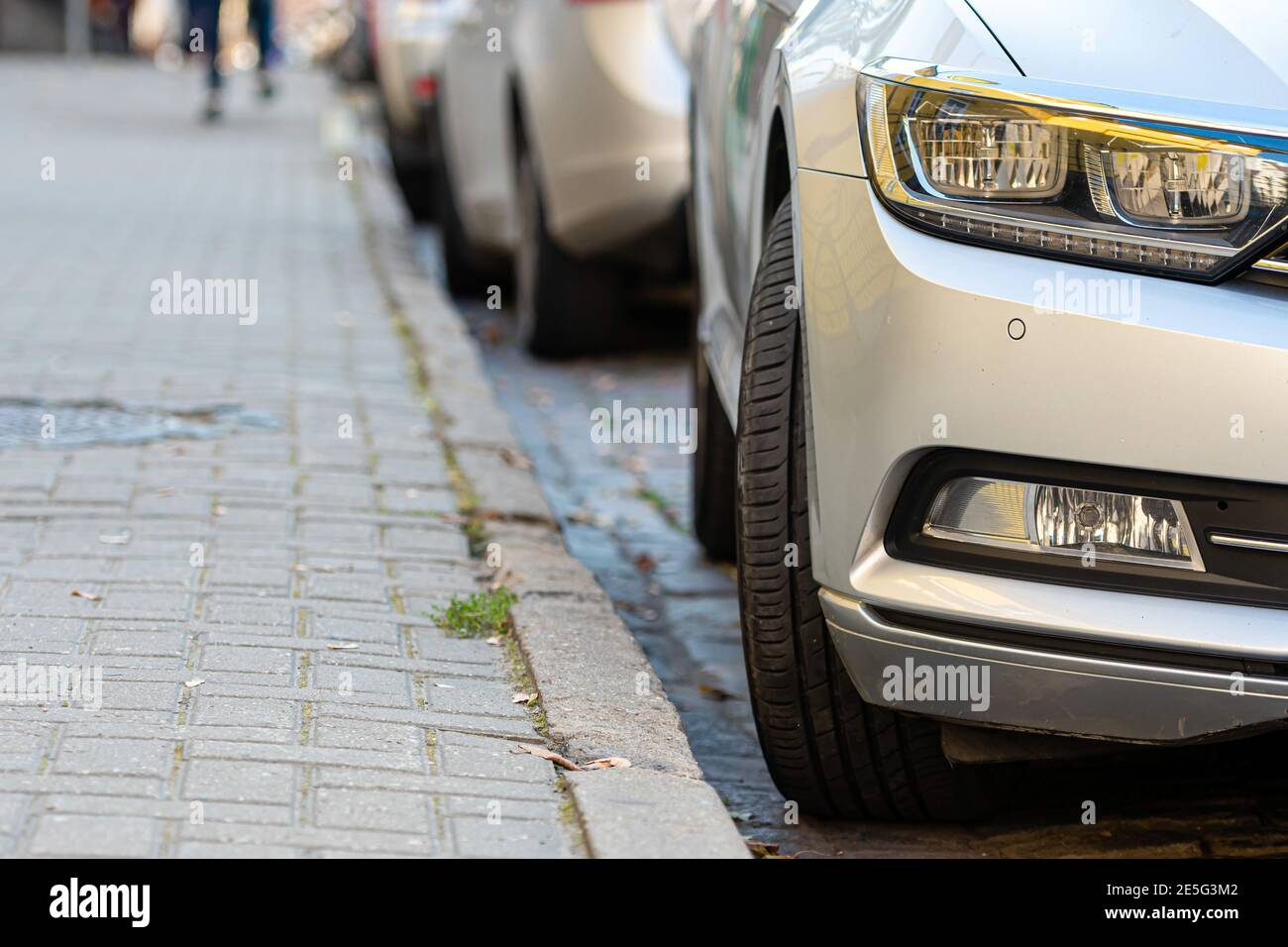 rows of different cars parked along the roadside in crowded city Stock ...