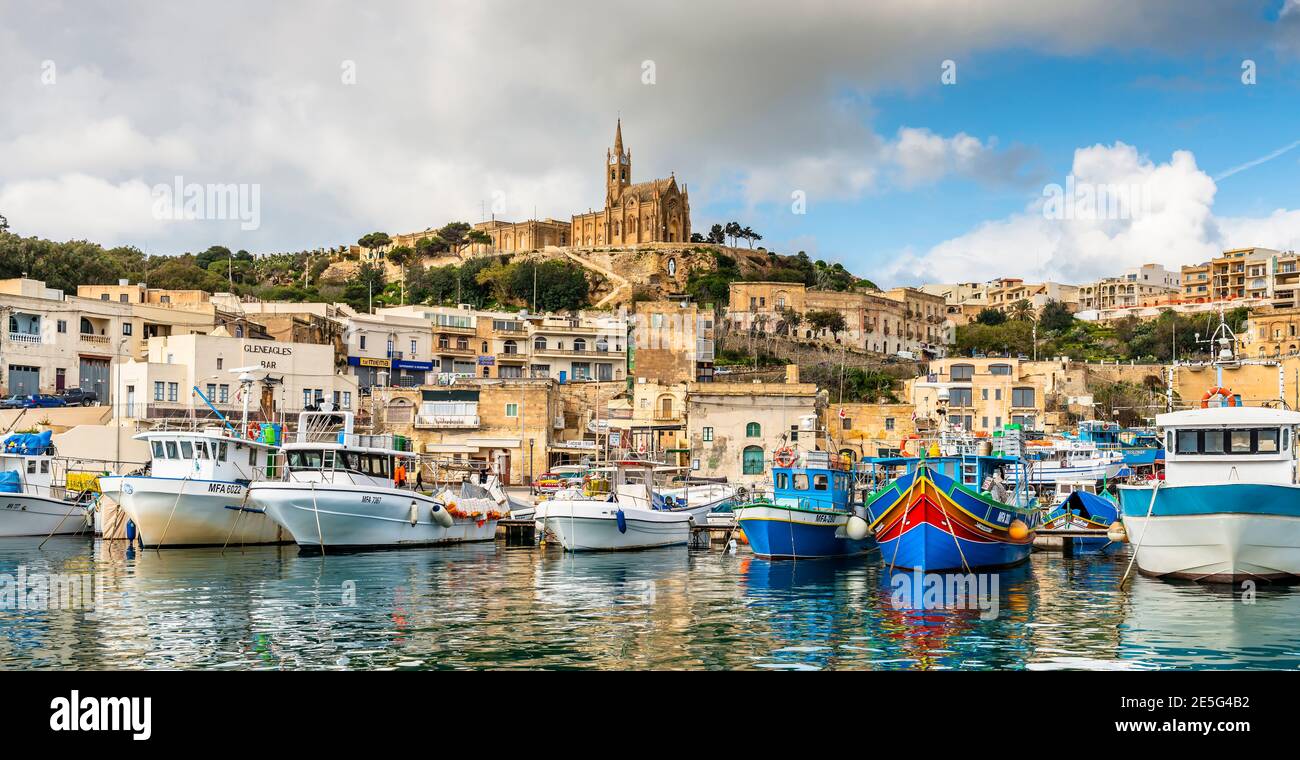 Port of the island of Gozo with its fishing boats, in Malta in the far ...