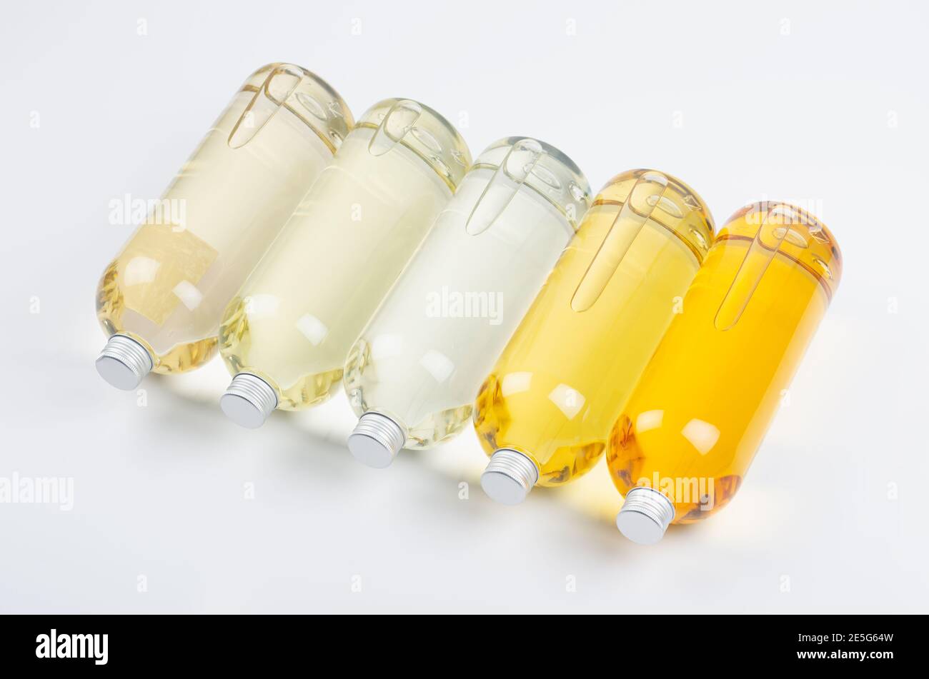 Collection transparent lying bottles with different pale colors liquid ...