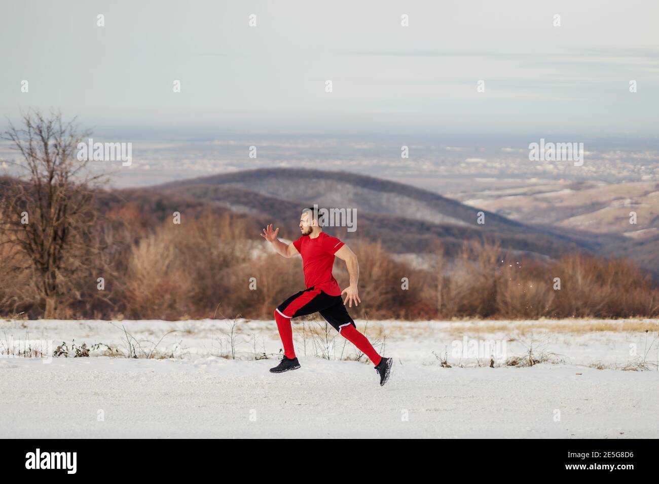 Fit sportsman sprinting on snow in nature at winter. Winter fitness ...
