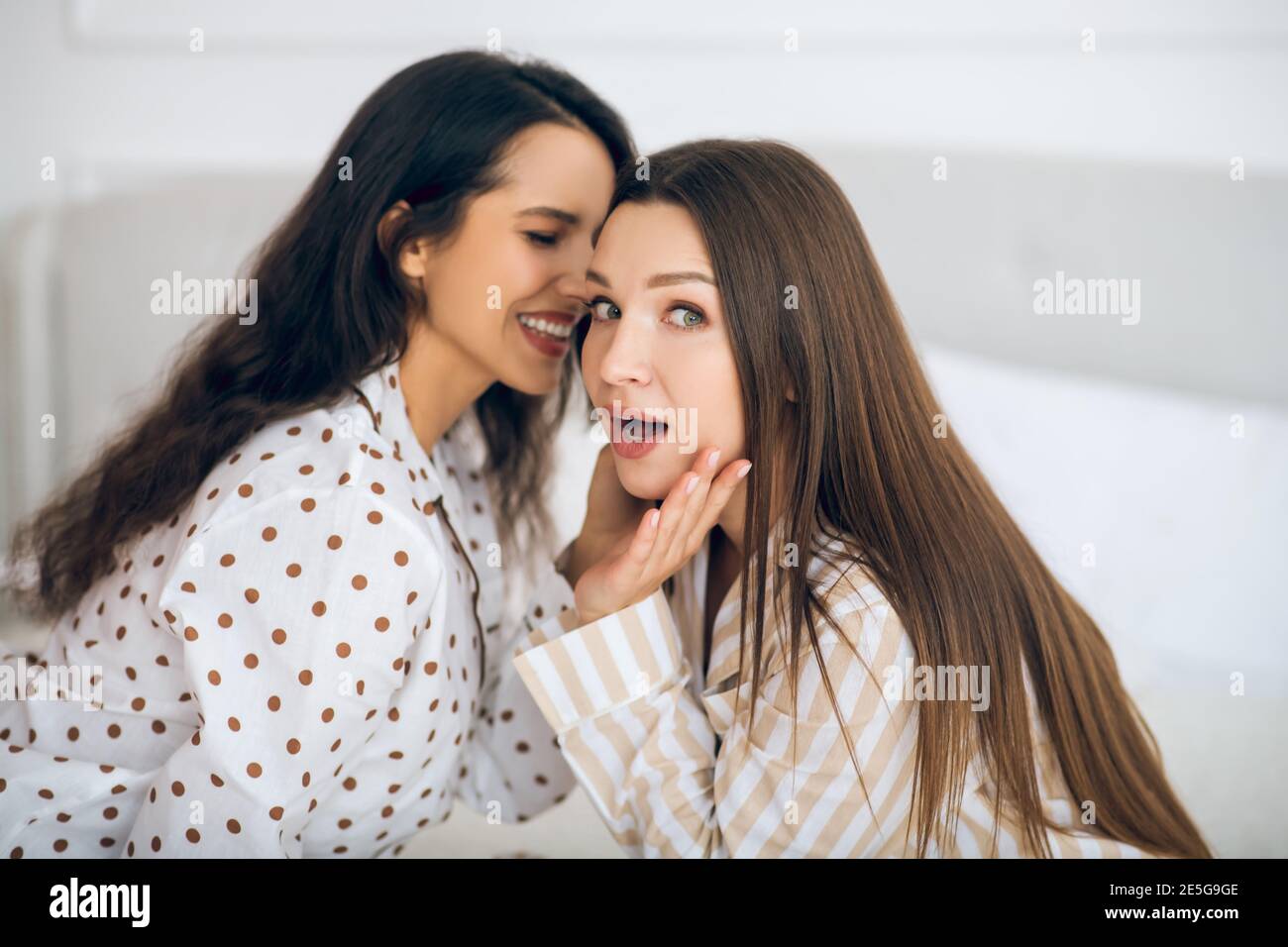 Two girls sharing secrets together hi-res stock photography and images ...
