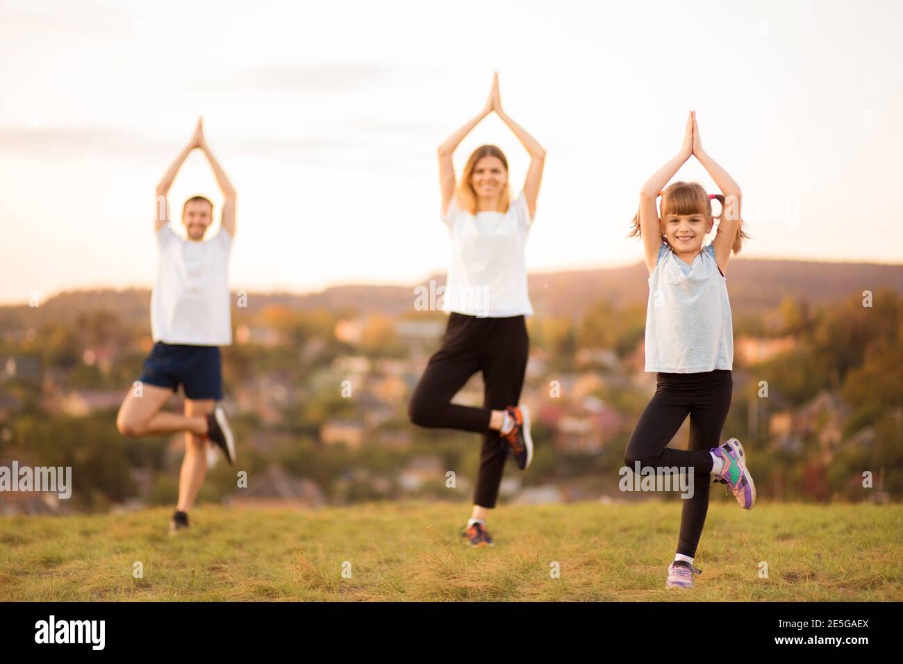 Sporty healthy active family of three do sport exercises together ...