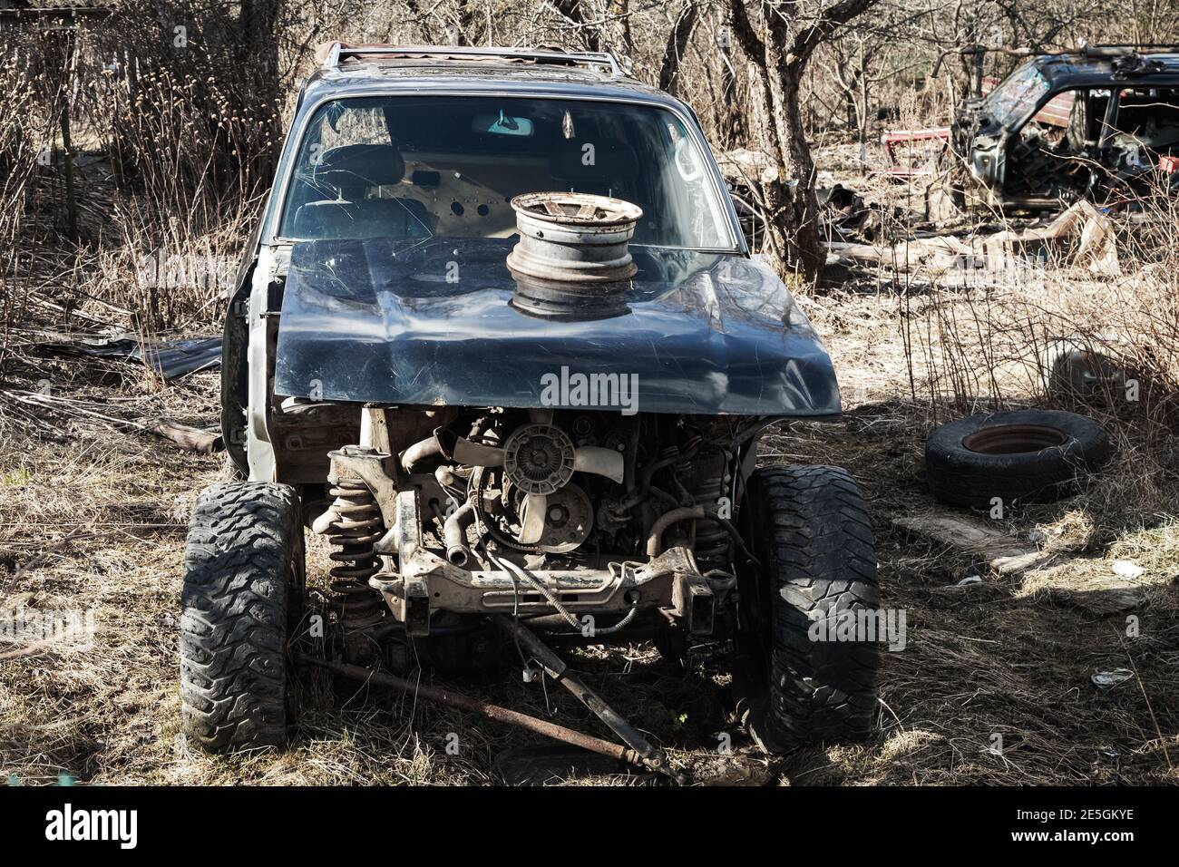 Abandoned broken SUV car standing on a dry grass at daytime, front view ...