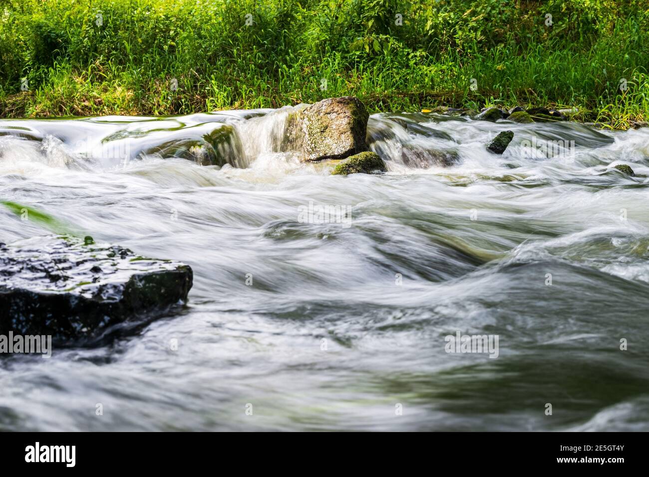 River flow over rocks in summer day. Waves of the river flow. Relaxing ...