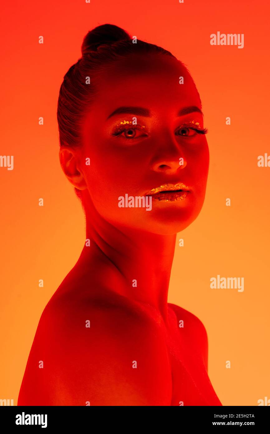 Fire. Handsome woman's portrait isolated on orange studio background in ...