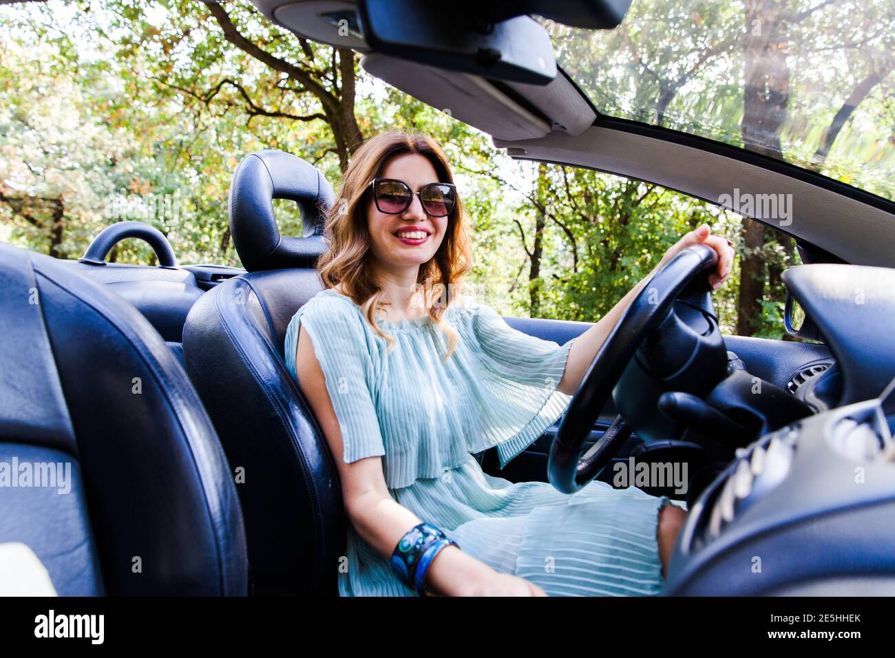 Beautiful young happy smiling woman driving convertible car. Cheerful ...