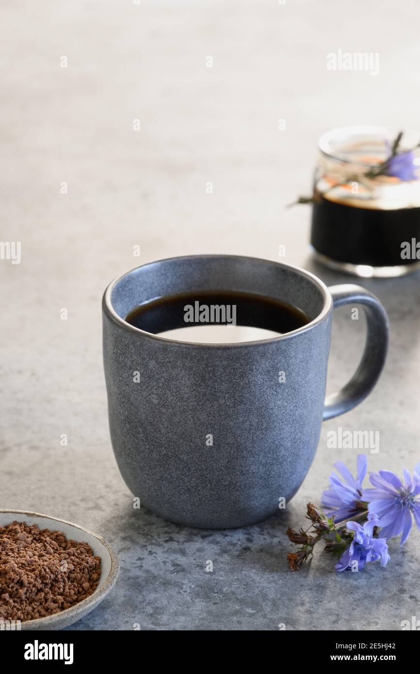Chicory beverage as coffee substitute in grey cup and fresh flowers ...