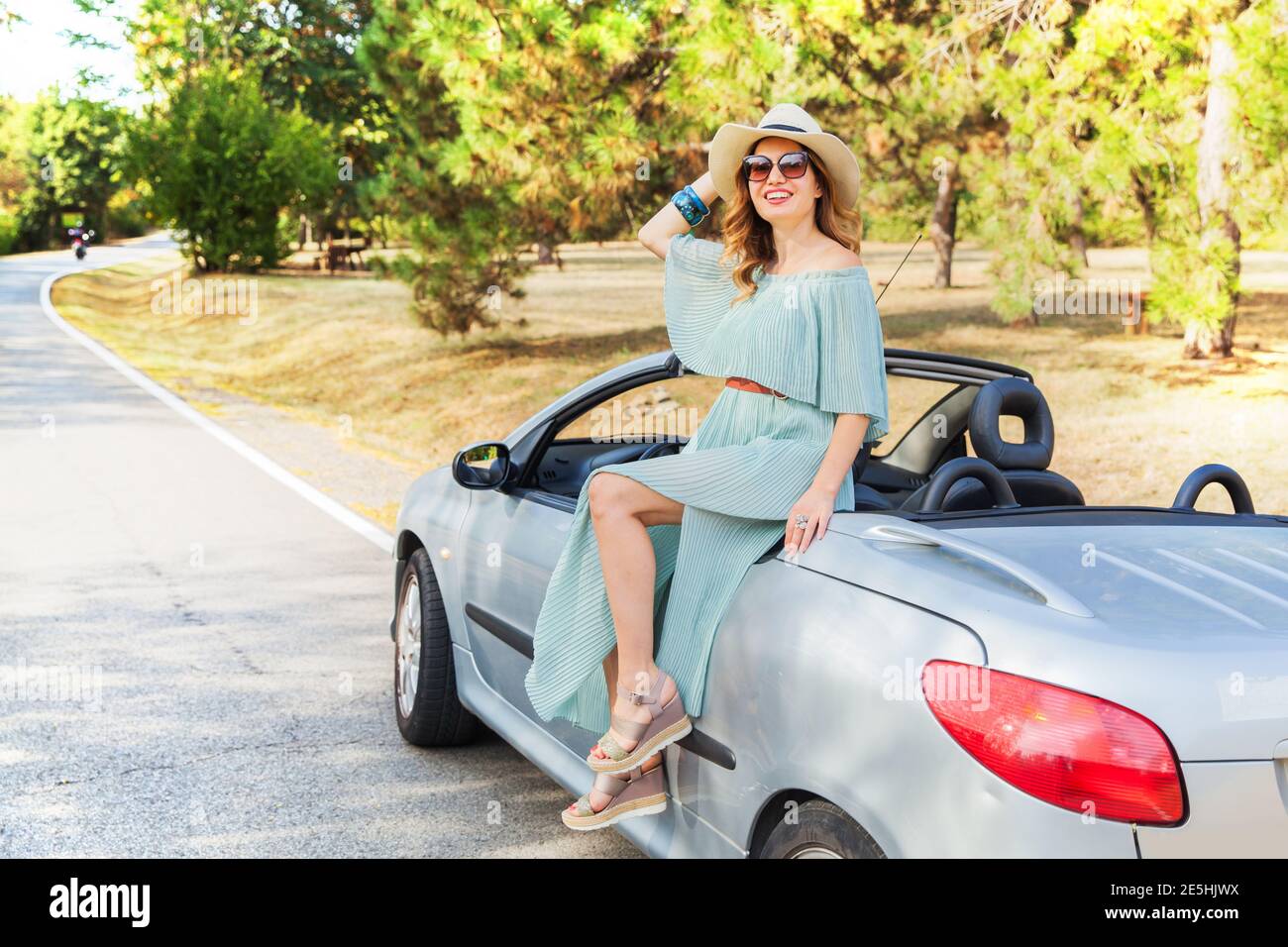 Attractive woman posing at convertible car. Happy pretty girl. Outdoor ...