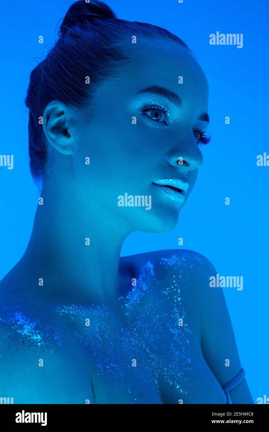 Alien. Handsome woman's portrait isolated on blue studio background in ...