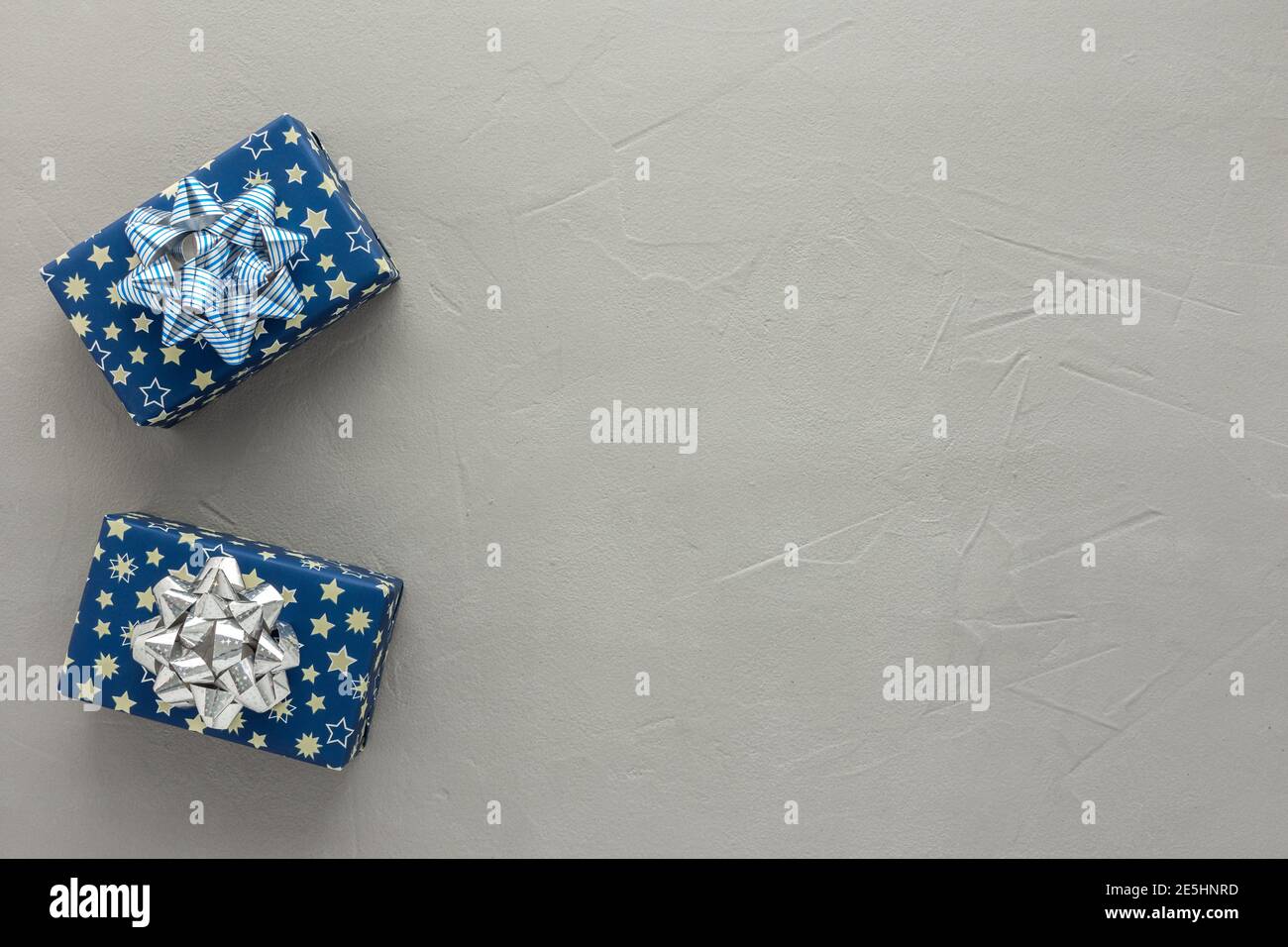 Gift boxes in blue beautiful wrapper with stars and a bow on a gray ...