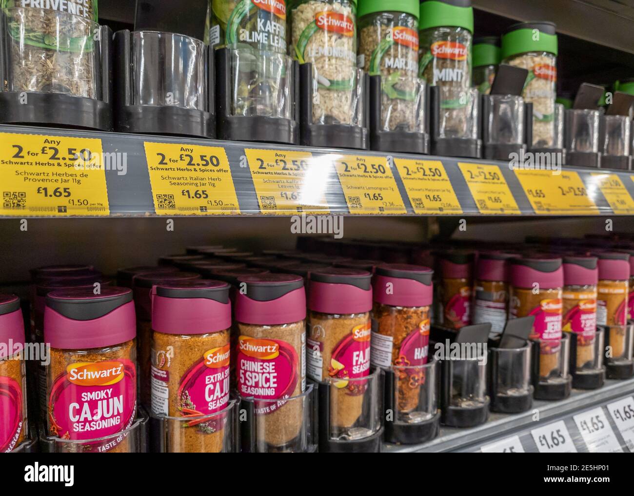 A row of spices in glass jars on display on supermarket shelves Stock ...